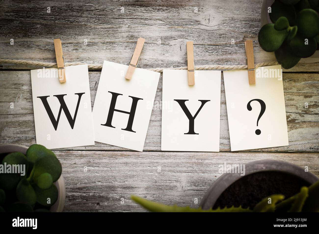 A set of printed cards spelling the word WHY on an aged wooden ...