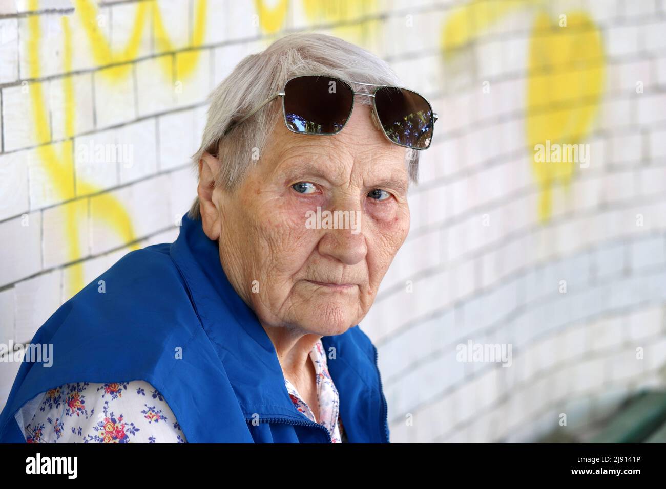 Portrait of elderly woman sitting on a bus stop. Life in retirement ...