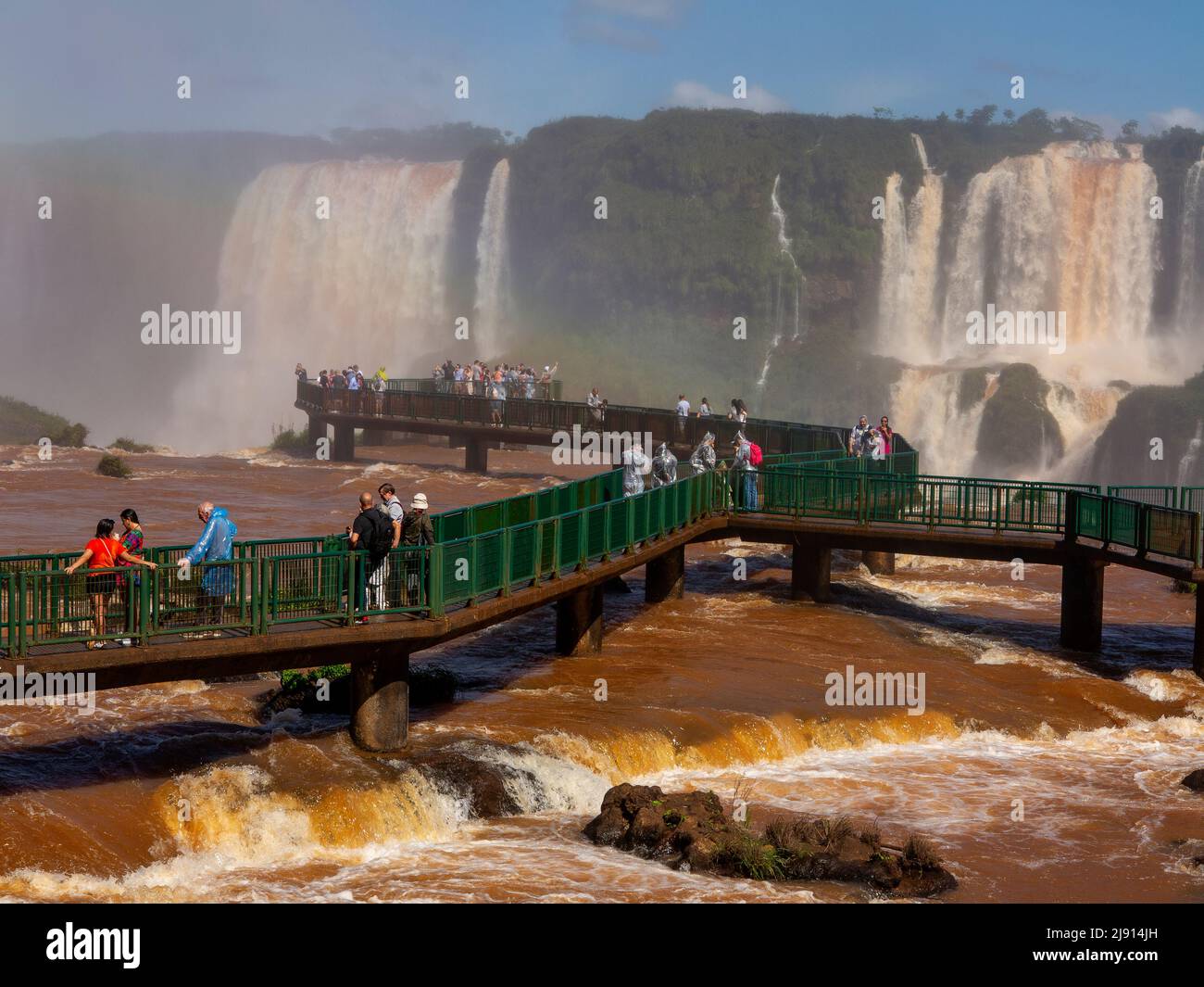 Tourists admiring the Iguazu Falls, one of the biggest falls in the ...