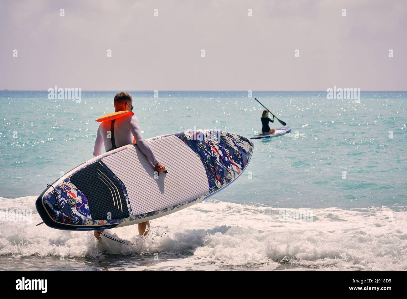 Man with sup board goes paddling Stock Photo - Alamy