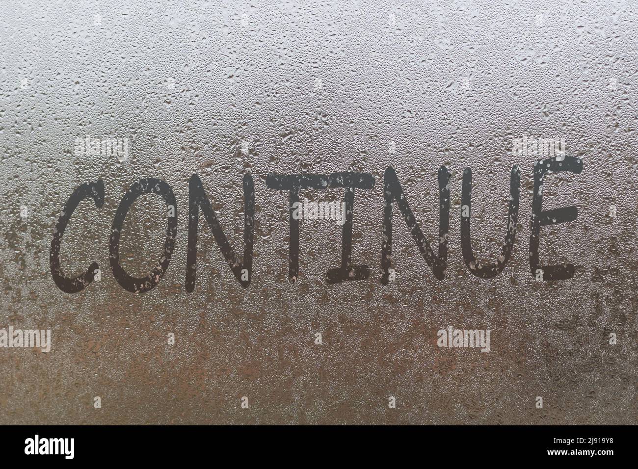 the word continue handwritten on night wet window glass Stock Photo - Alamy