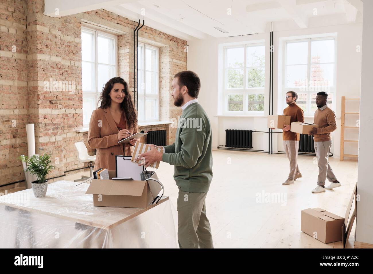 Group of young multi-ethnic colleagues changing office space: woman and ...