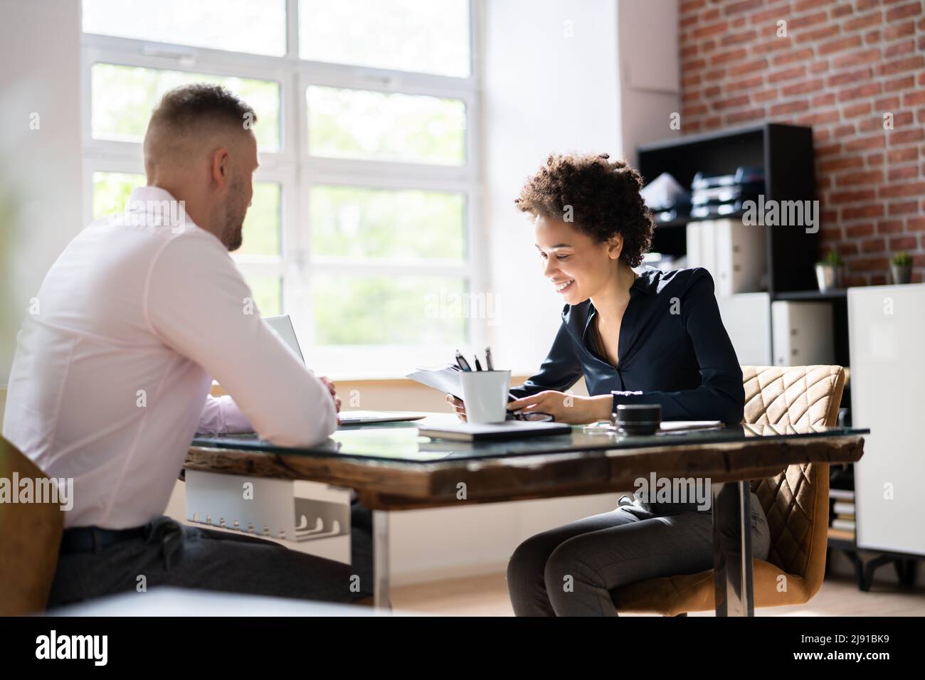 Mature Businesswoman Taking An Interview Of Man Over The Wooden Desk In ...