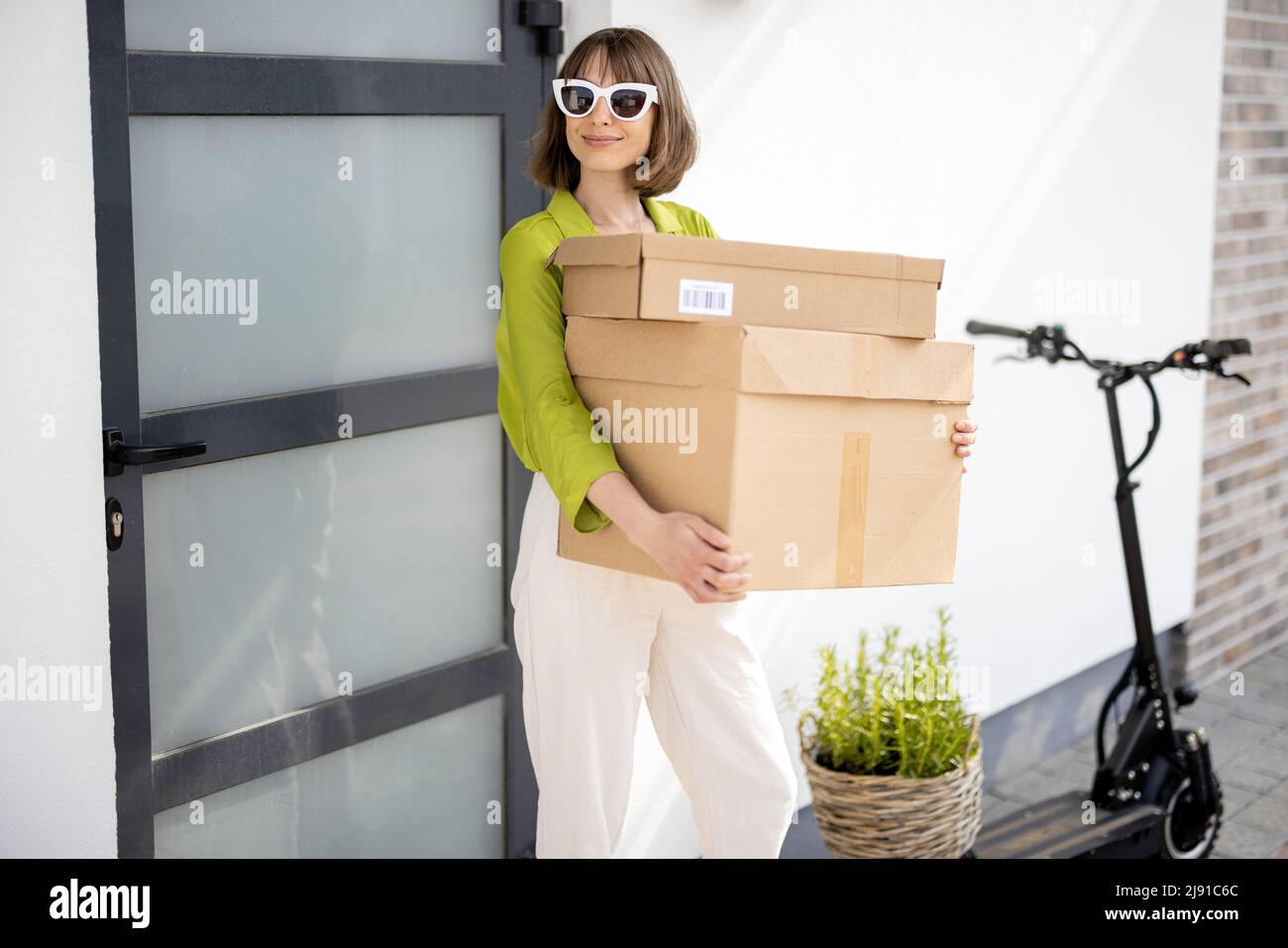 Woman carrying parcels while going home Stock Photo - Alamy