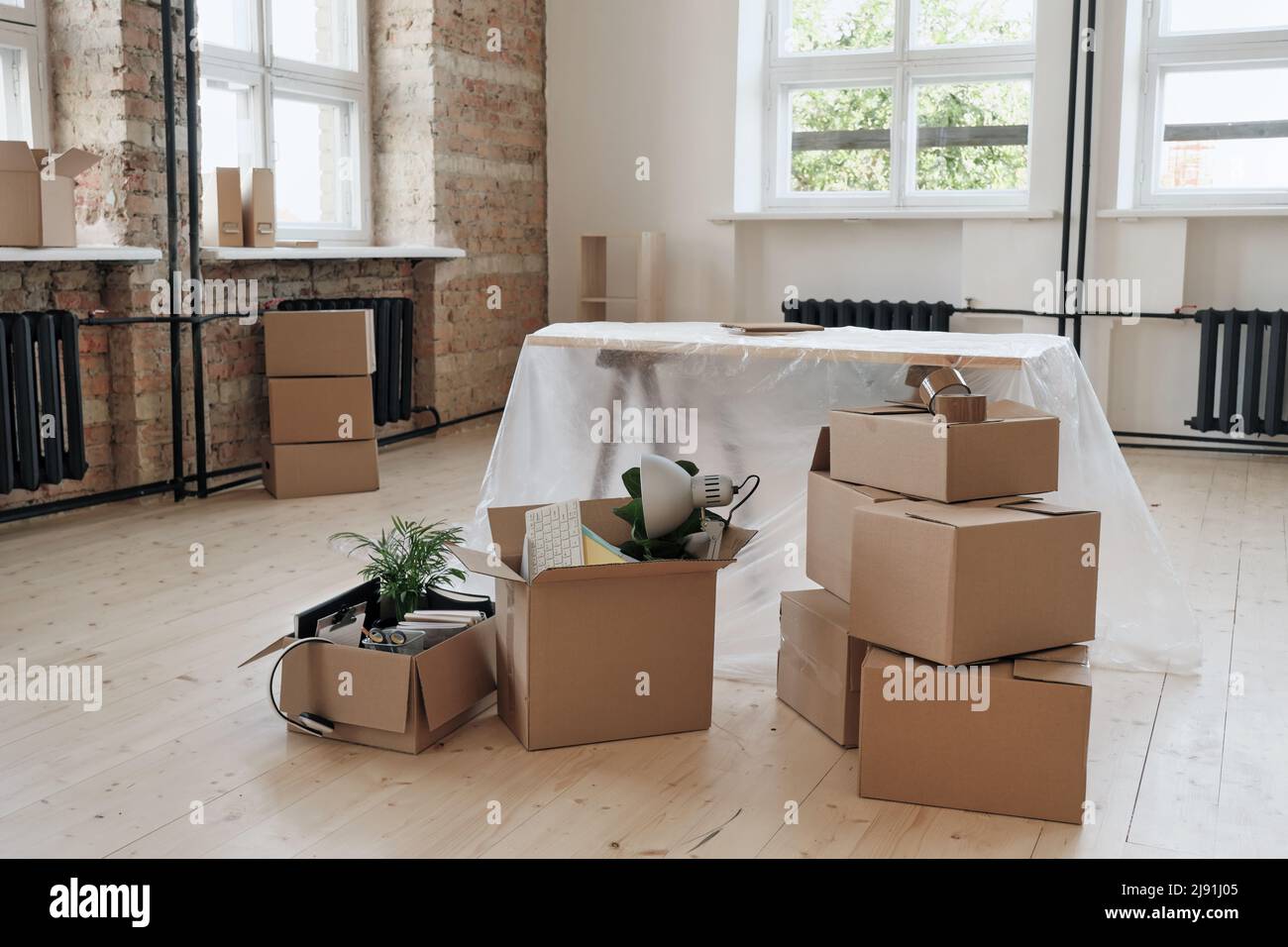 Office desk stuff into boxes placed on parquet floor in loft space ...