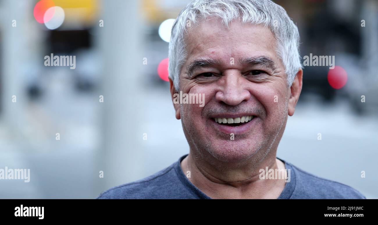 Portrait 60 year old man smiling at camera in city, casual and real ...