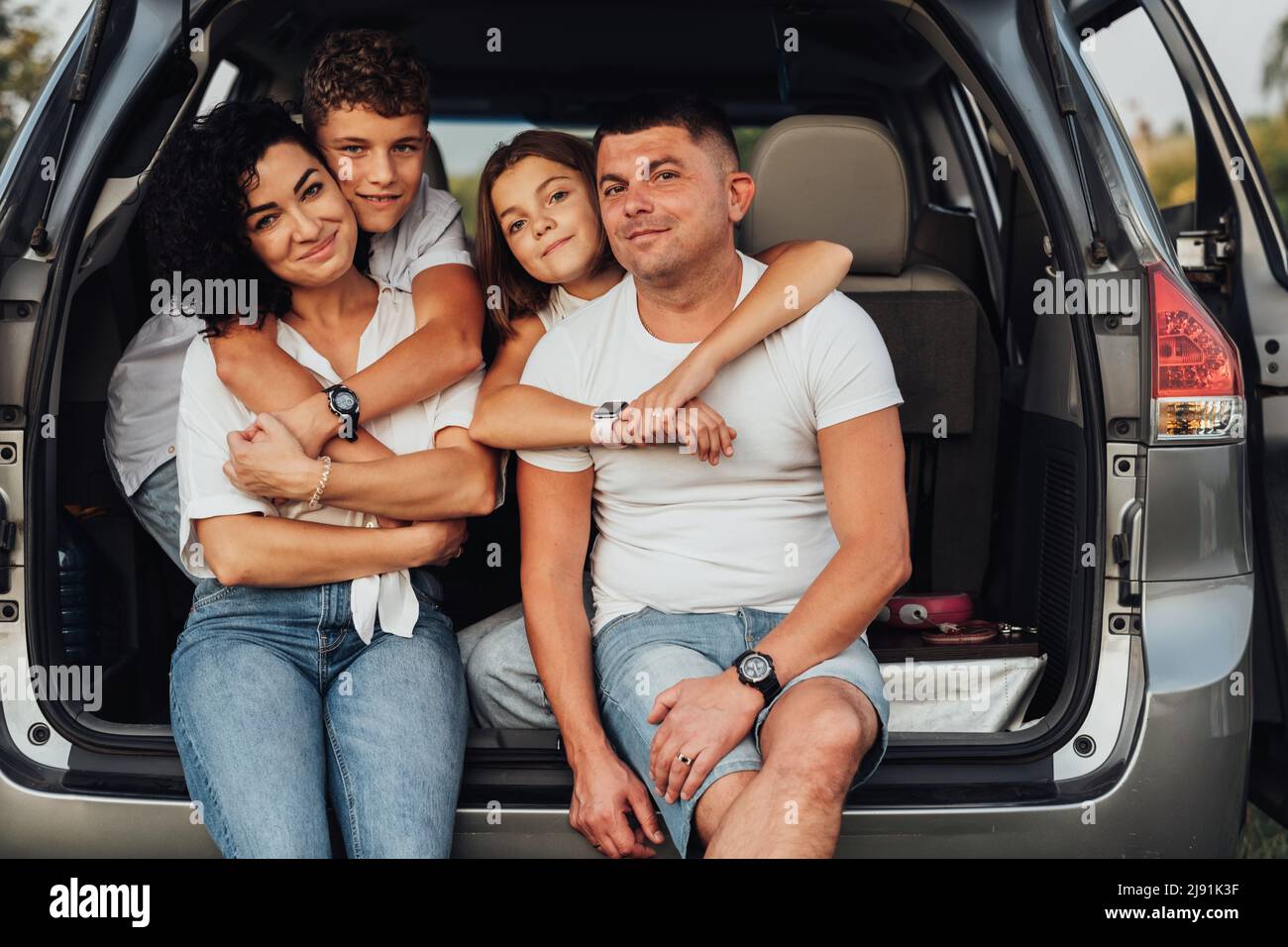 Portrait of Happy Four Caucasian Members Family Sitting in Trunk of the ...