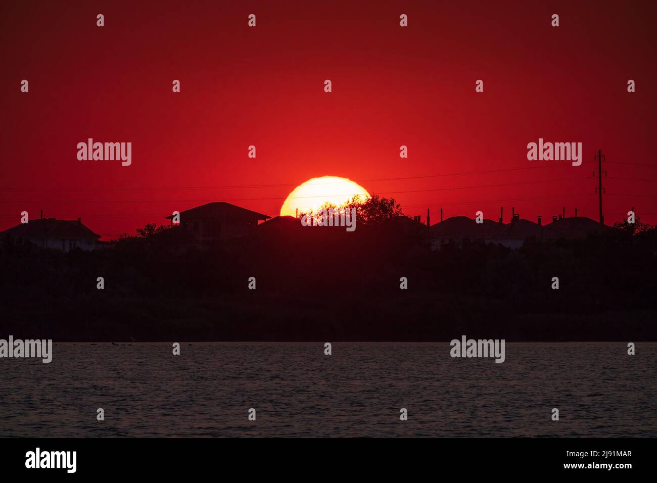 The sun goes down over a lake. Dramatic Sunset Sky Stock Photo - Alamy