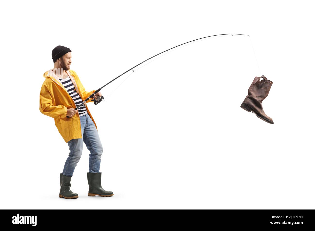 Full length profile shot of a fisherman in a raincoat catching an old ...