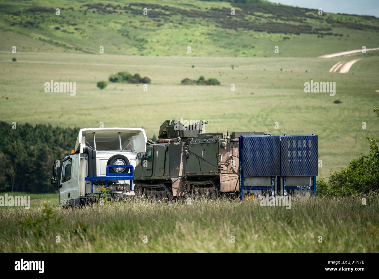 Flatbed low-loader transporter truck carrying a British Army BvS10 ...