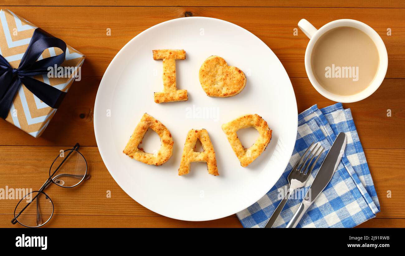 Happy Fathers Day breakfast. I Love Dad pastry on plate, napkin, cup of ...