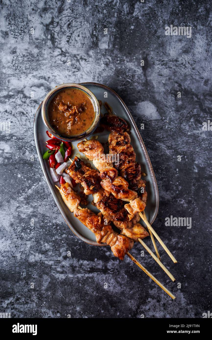 Indonesian chicken satay served with peanuts sauce Stock Photo - Alamy