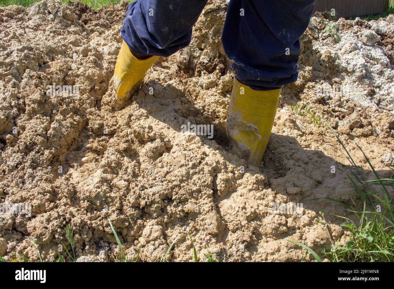 Image of the legs of a man in yellow boots sinking into the mud Stock ...