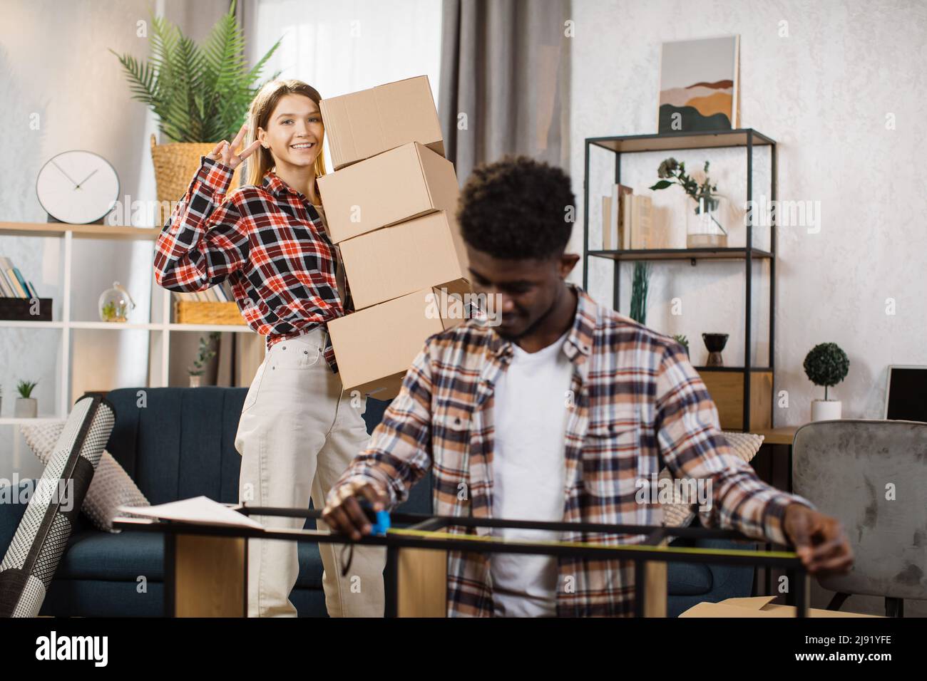 Cute caucasian woman making peace sign joyfully to camera while holding ...