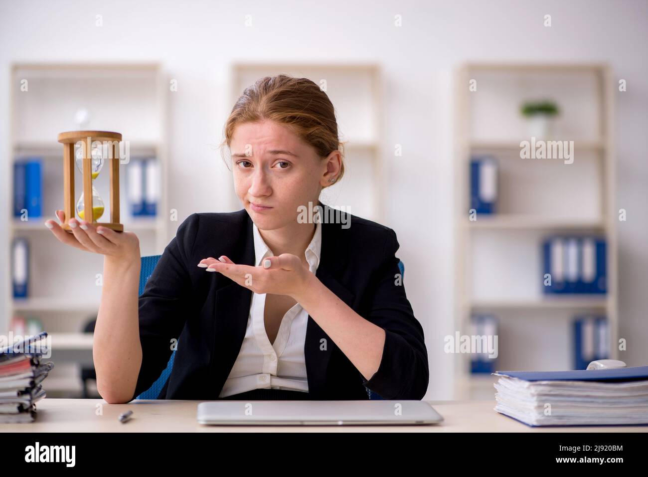 Female employee in time management concept Stock Photo - Alamy