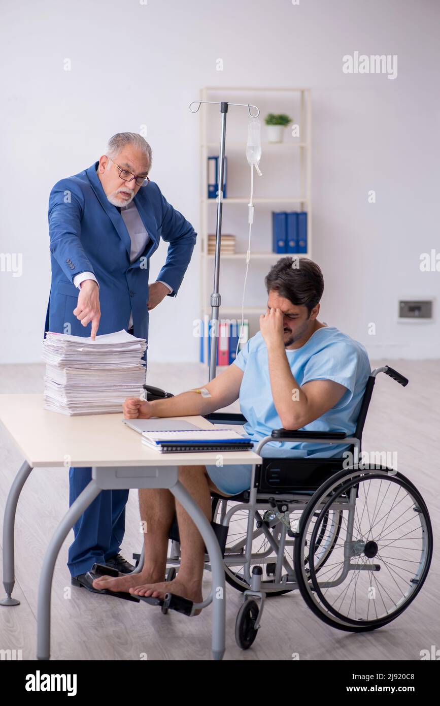 Young employee in wheel-chair feeling bad at workplace Stock Photo - Alamy