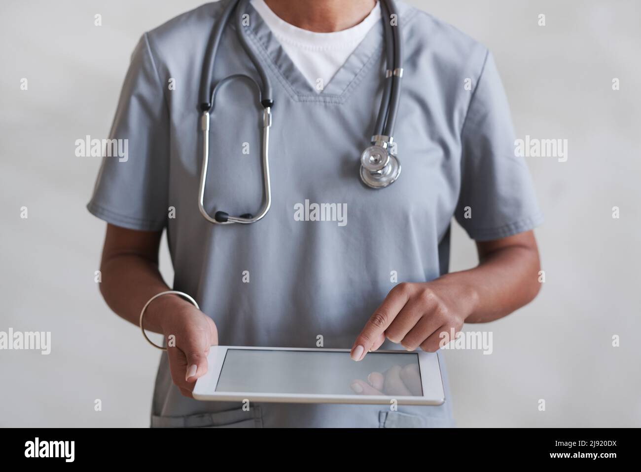 Medium section studio shot of unrecognizable female doctor wearing gray ...