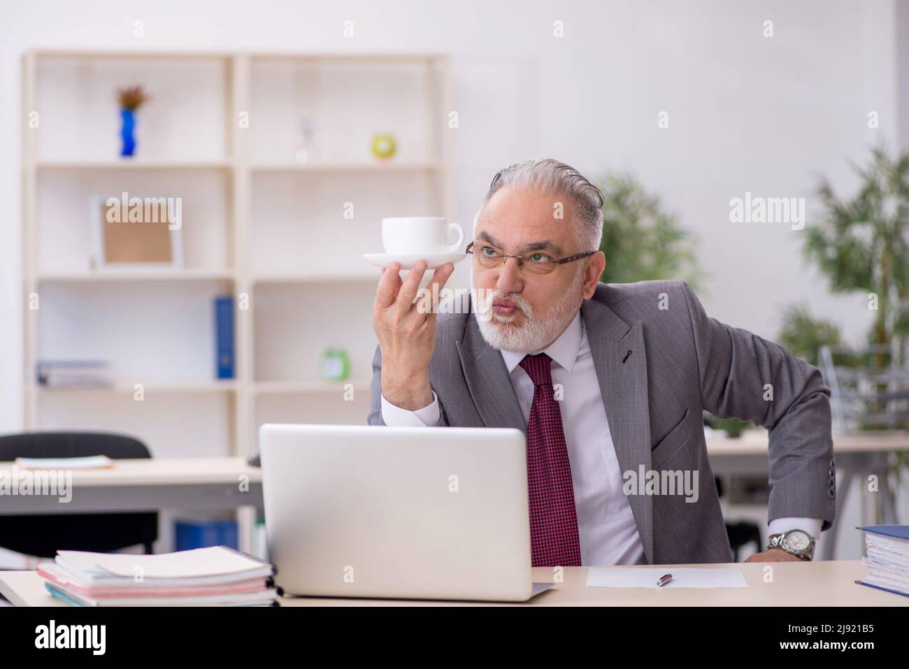 Old employee drinking coffee during break Stock Photo - Alamy