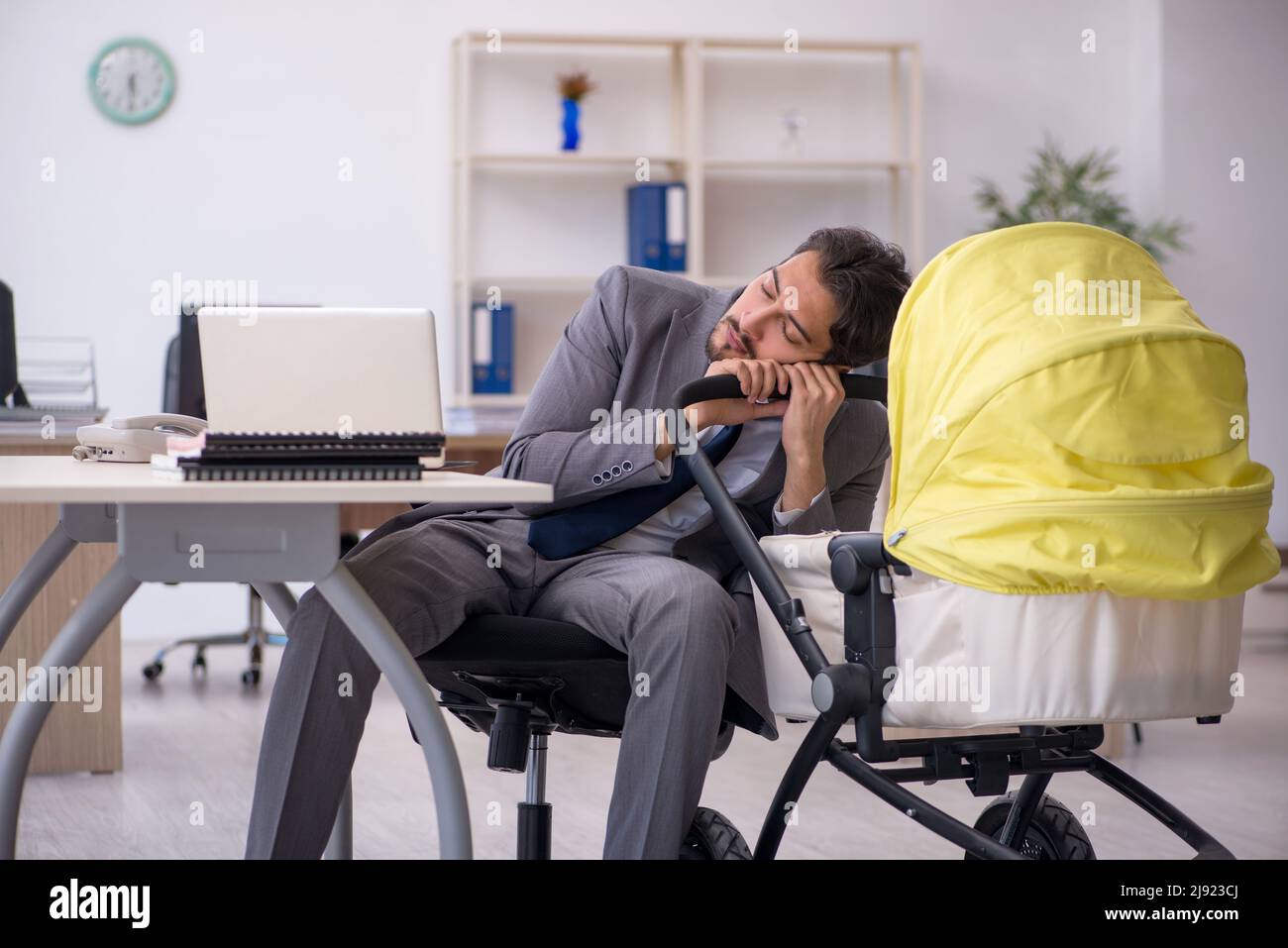 Young businessman employee looking after new born in the office Stock ...