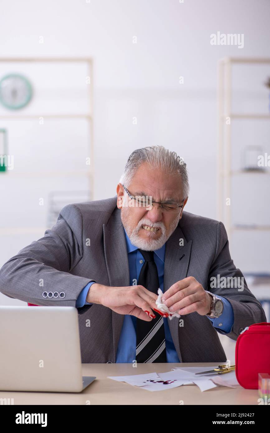 Old businessman employee cutting his hand at workplace Stock Photo - Alamy