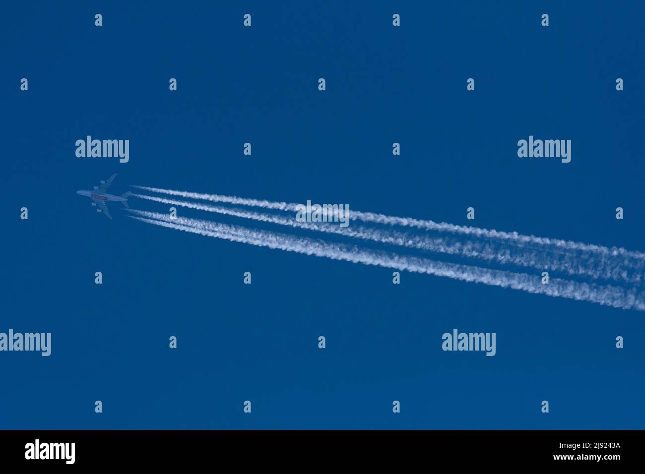 Vapour trail of a four-engine commercial aircraft of Emirates Airline ...