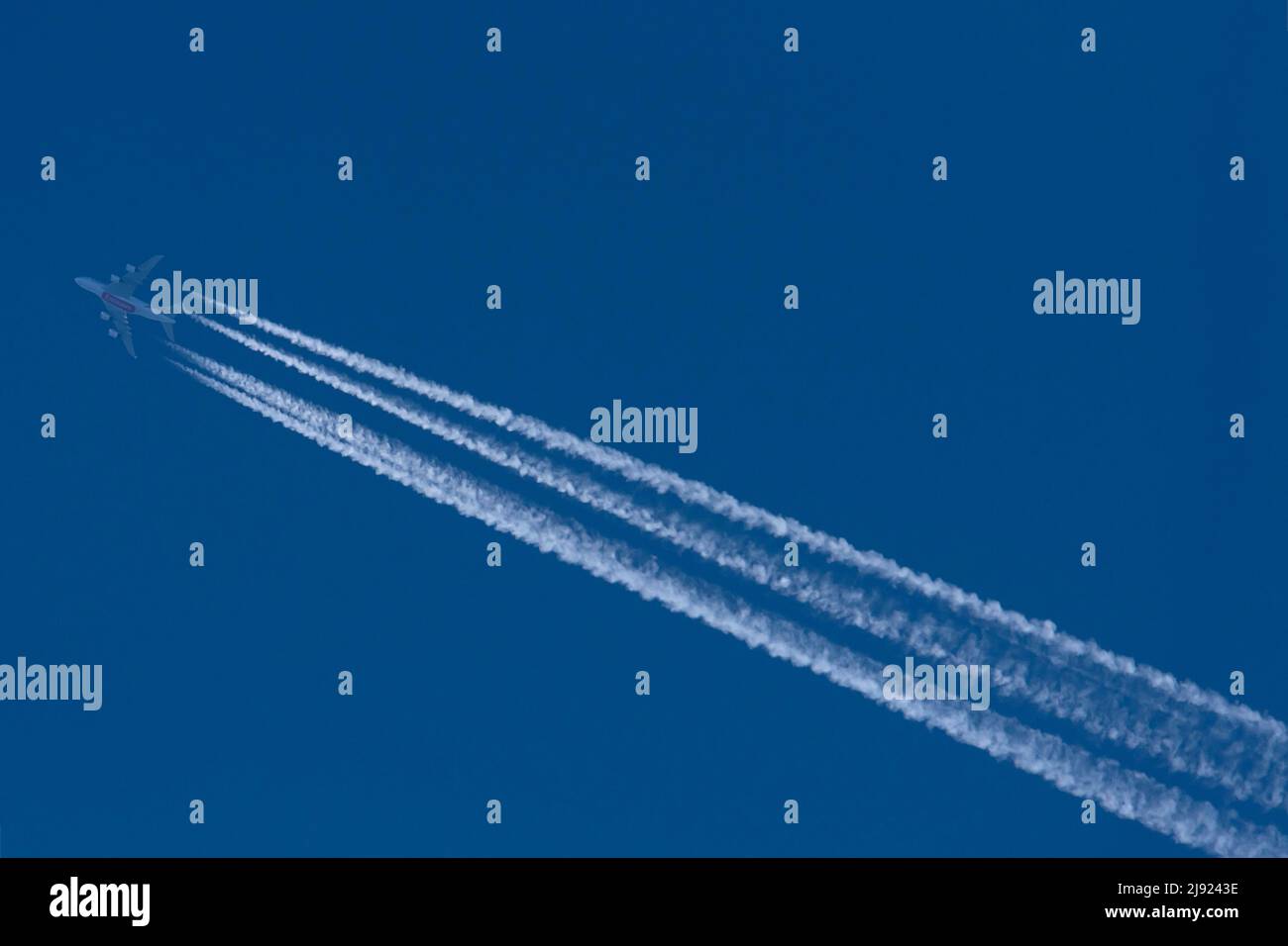 Vapour trail of a four-engine commercial aircraft of Emirates Airline ...