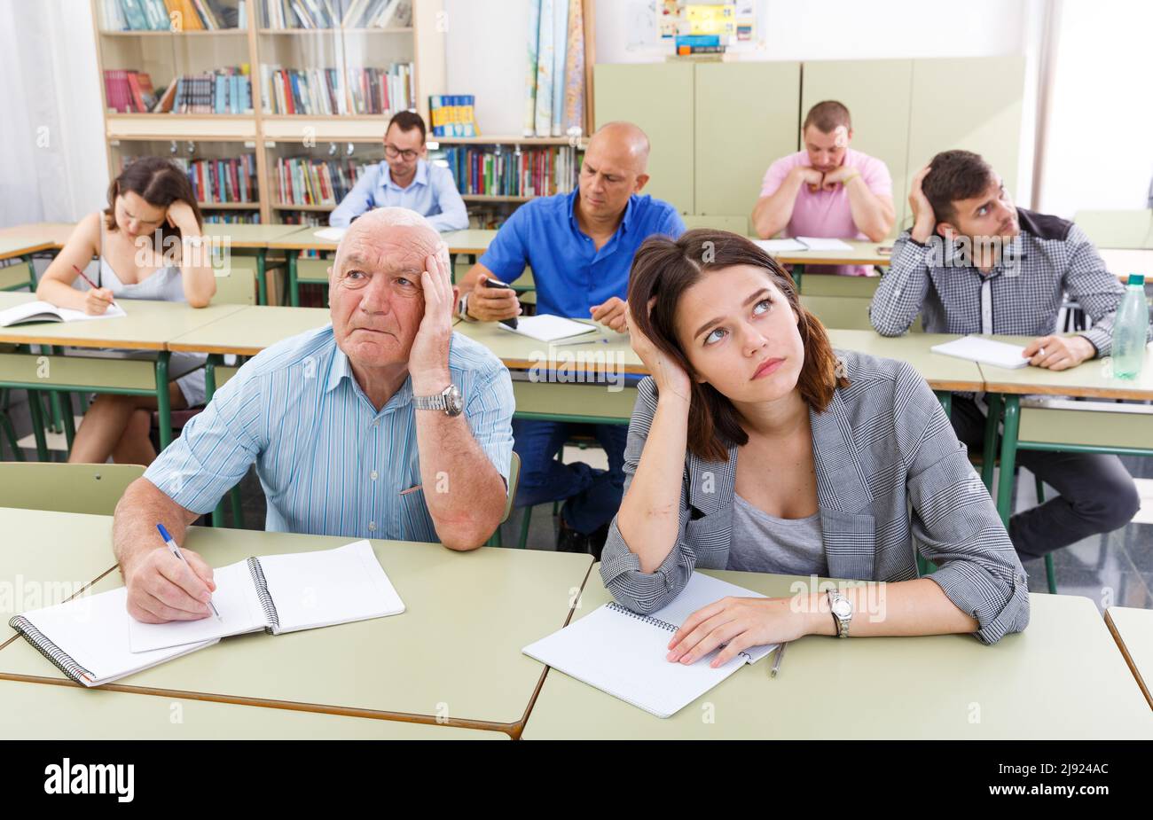 Sad students different ages listening task Stock Photo - Alamy