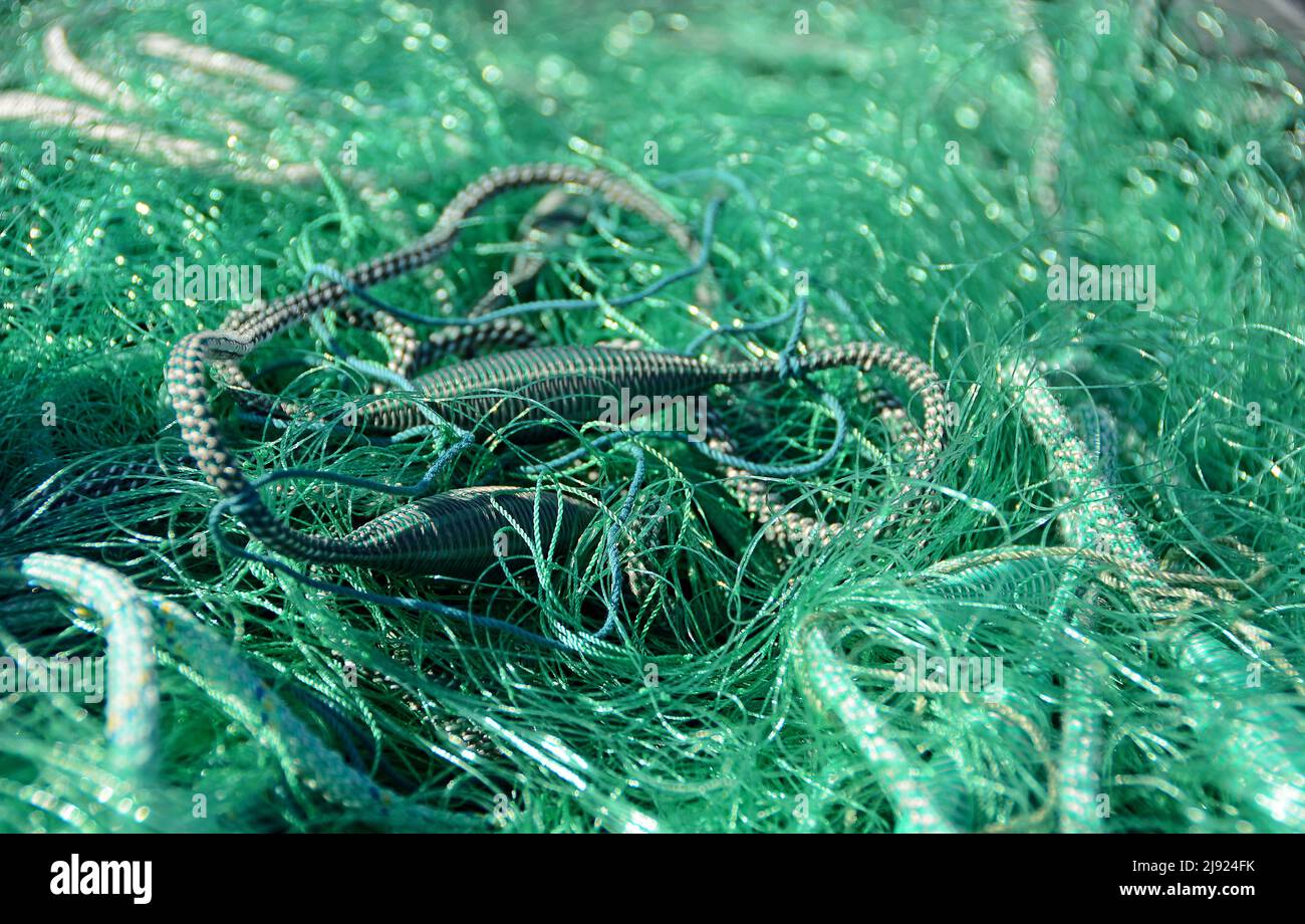 Green fishing net with rope and floats Stock Photo - Alamy