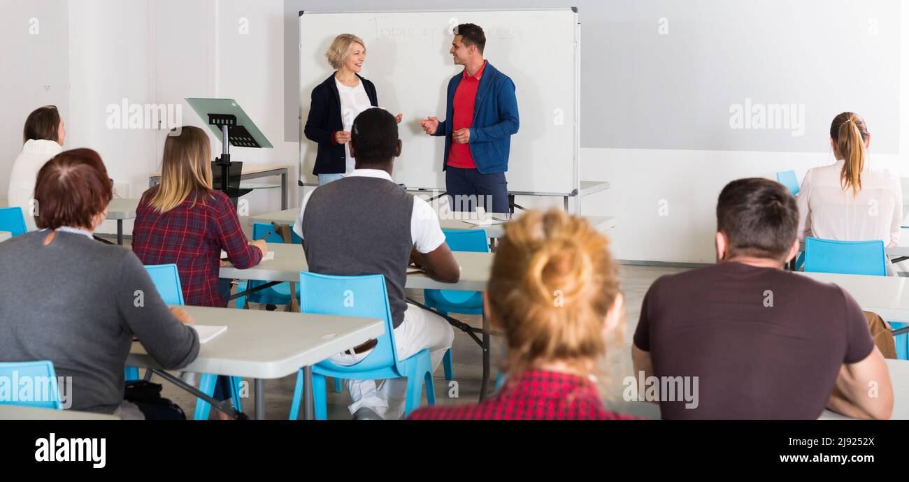 Students with teacher studying in classroom Stock Photo - Alamy