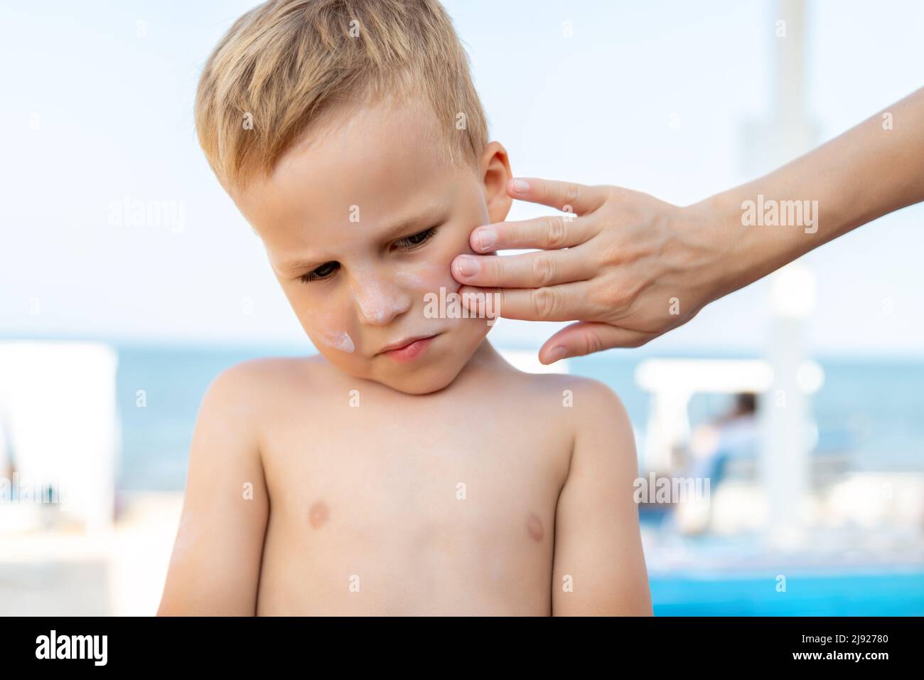 Mother applying sunscreen protection creme on cute little baby boy kid ...