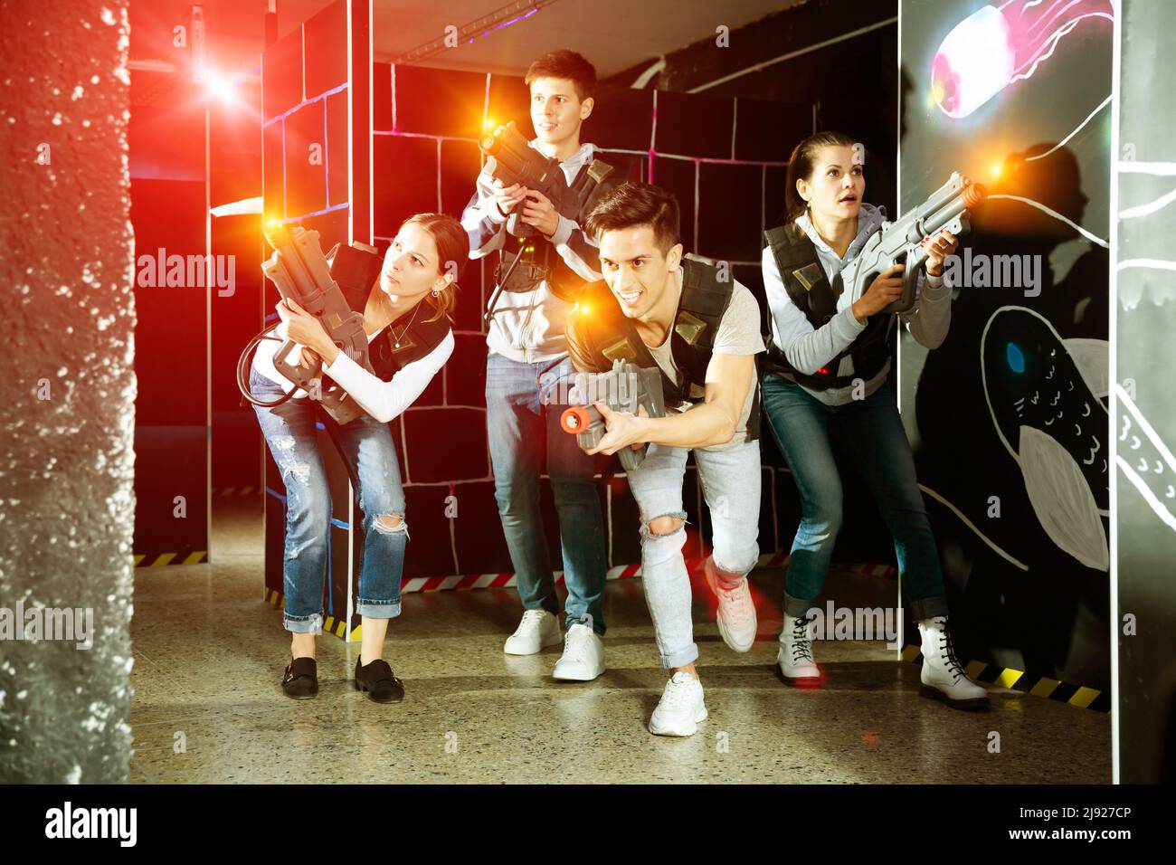 Guy with friends playing laser tag Stock Photo - Alamy