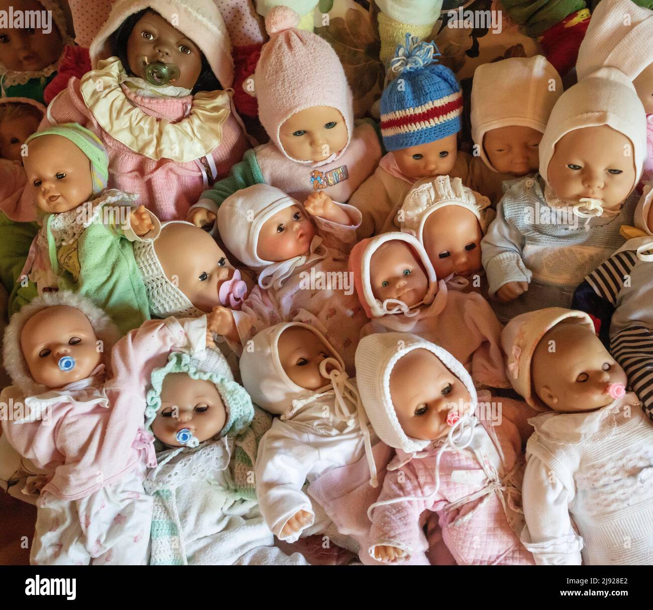 Various decorative dolls and baby dolls lying together, children's toys ...