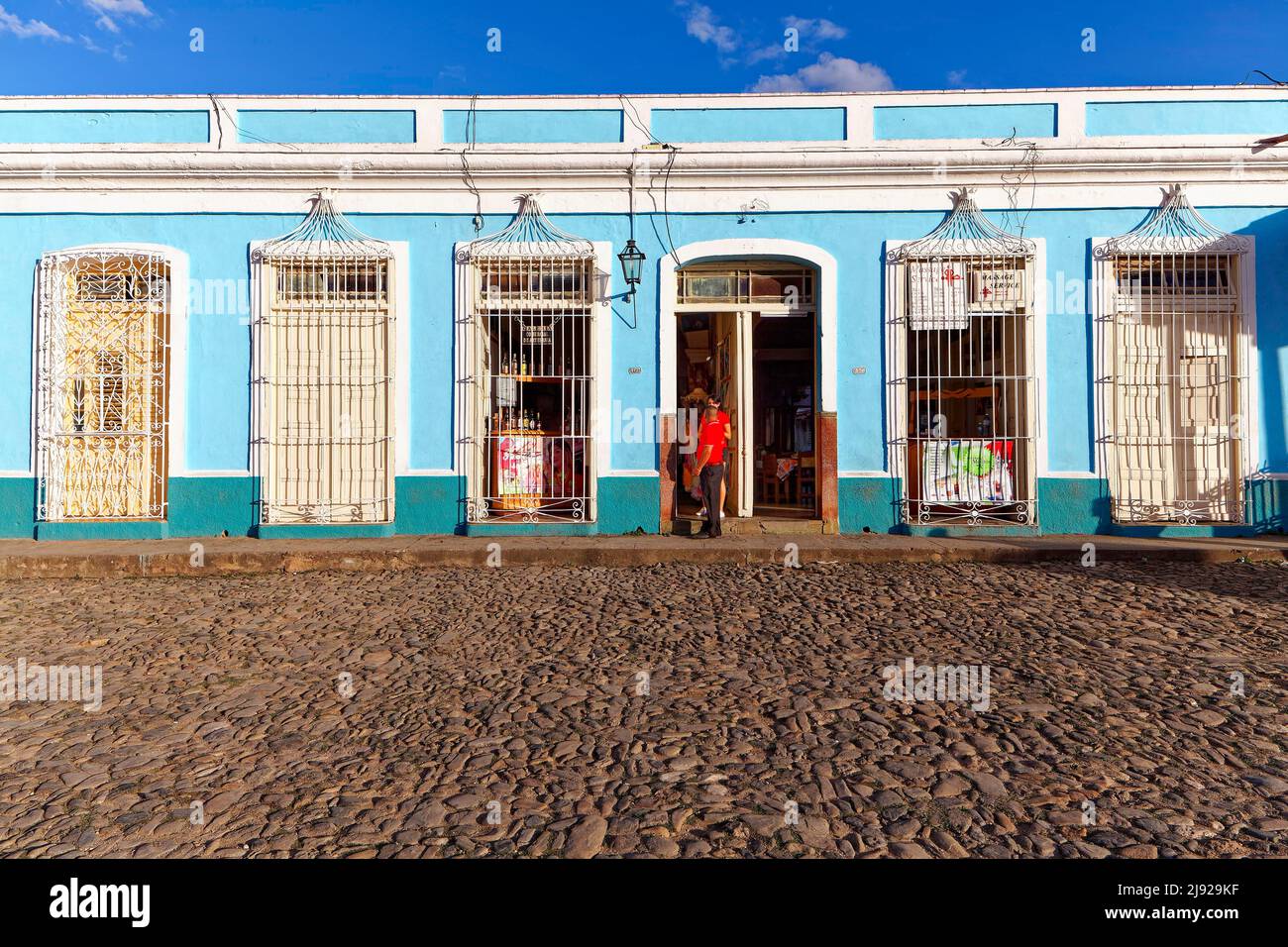 Cubans in front of shop, cobbled street, colonial house with typical ...