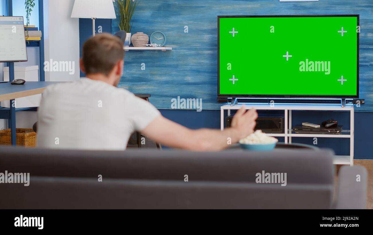 Sports fan watching game on green screen tv mockup encouraging ...