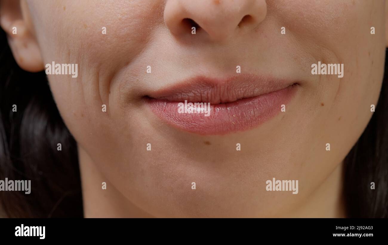 Macro shot of female model smiling and moving lips on camera, showing ...