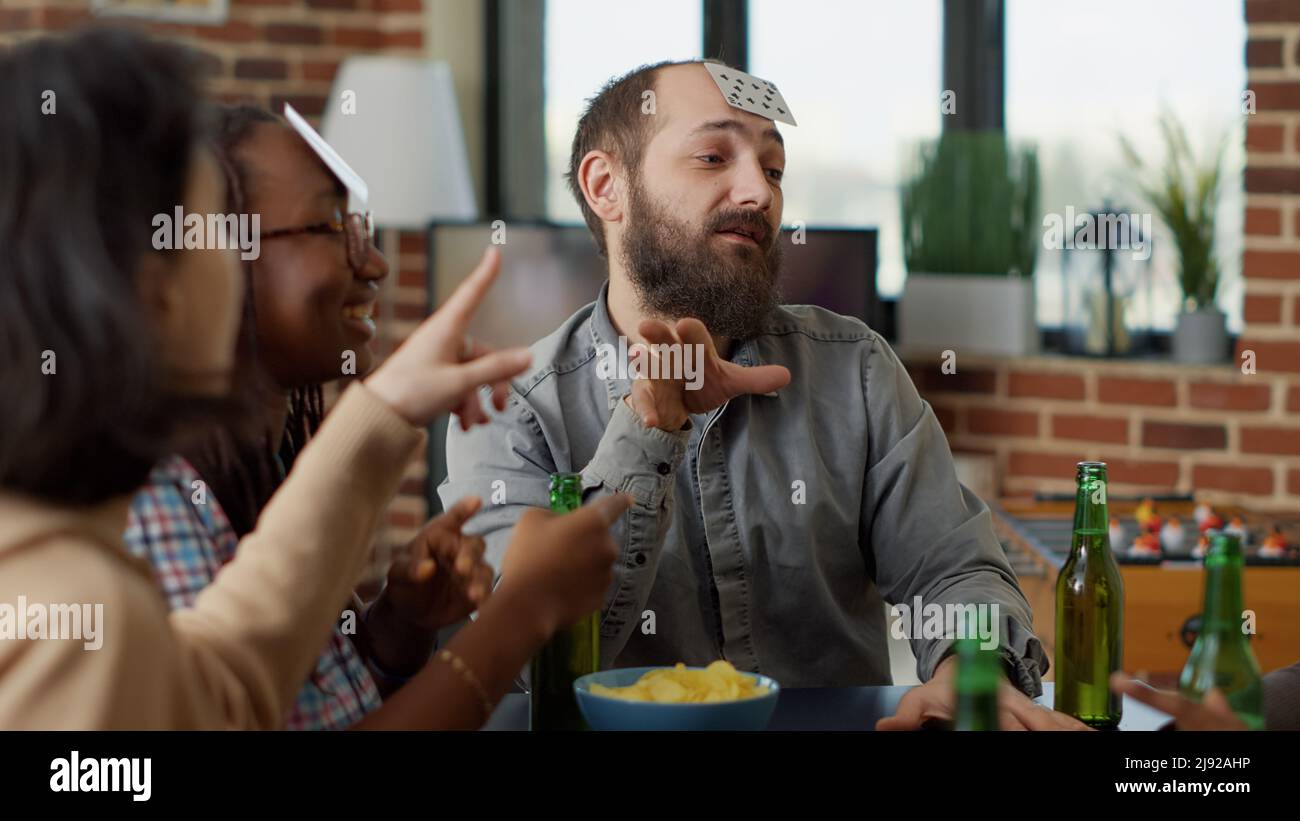 Multiethnic group of people laughing together at board games play with ...