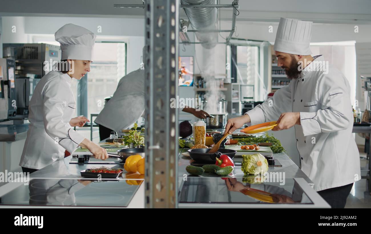 People cooking professional food recipe in restaurant kitchen, using ...