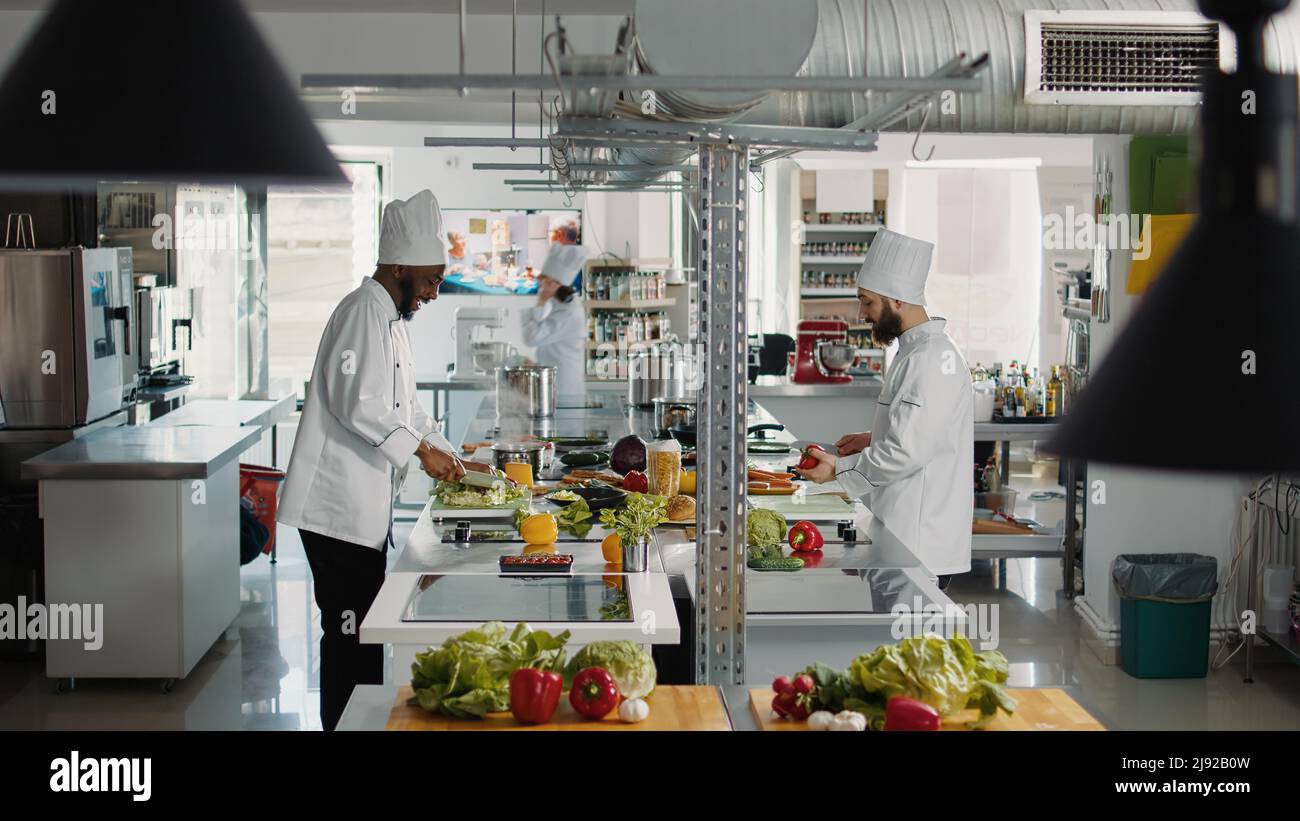 Diverse team of chefs preparing ingredients for culinary recipe ...