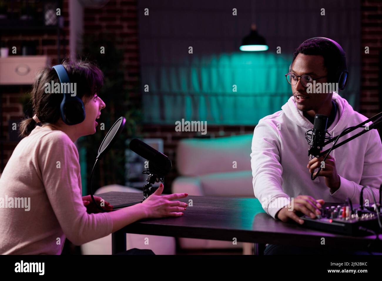 Male influencer hosting podcast livestream with woman, recording online ...