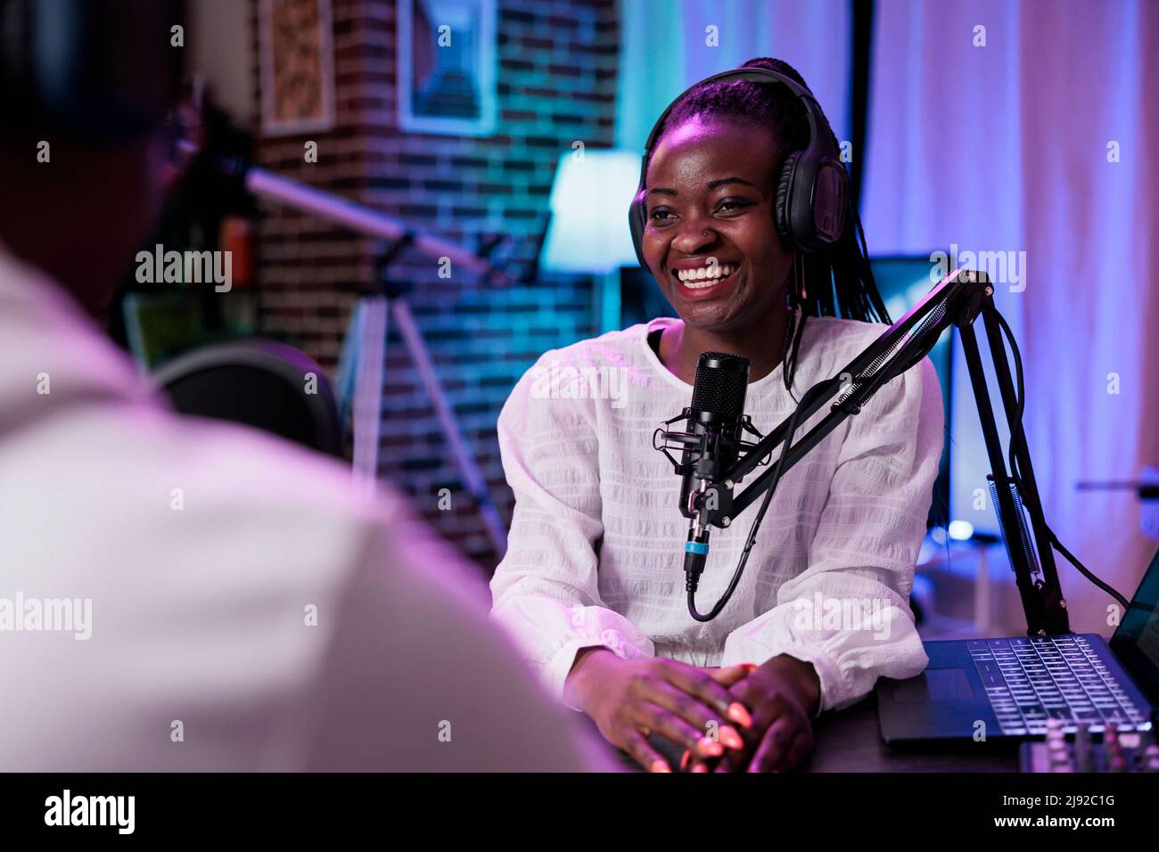 Female influencer interviewing guest on podcast stream, using recording ...