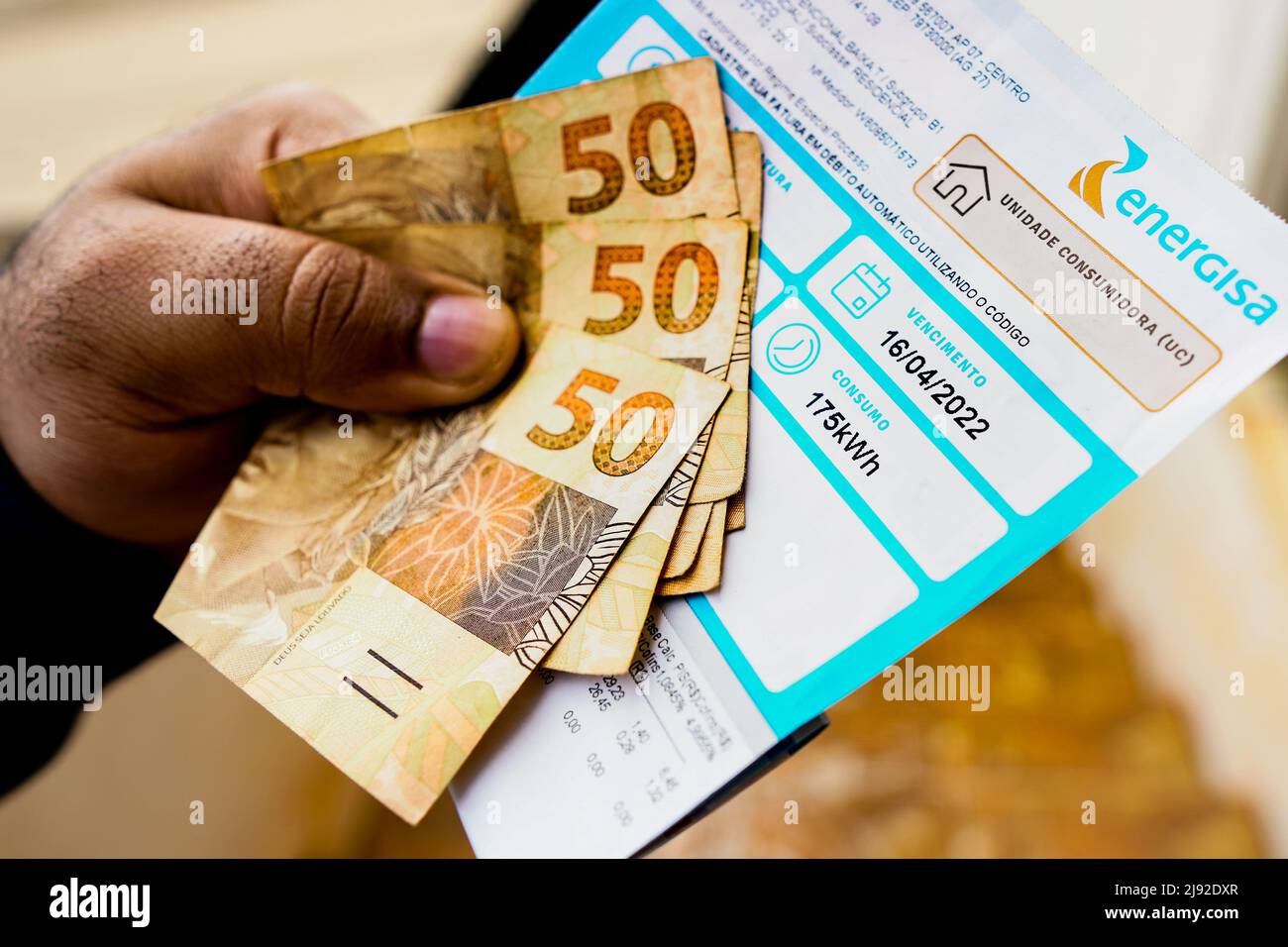 In this photo illustration, a consumer holds an electricity bill ...