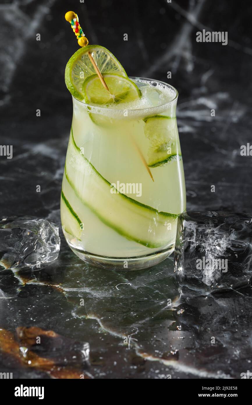Gin gimlet cocktail garnished with cucumber. Green alcohol cocktail ...
