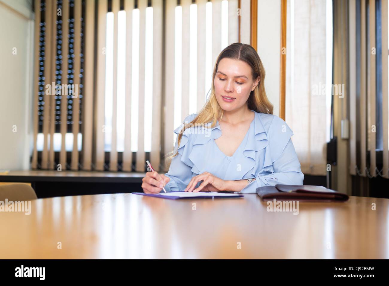 Business woman in office interior filling up documents Stock Photo - Alamy