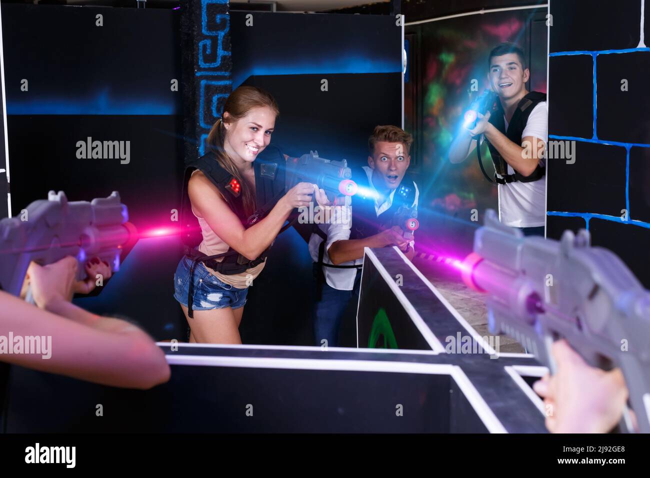 Teams of laser tag game emotional girls and guys playing togethe Stock ...