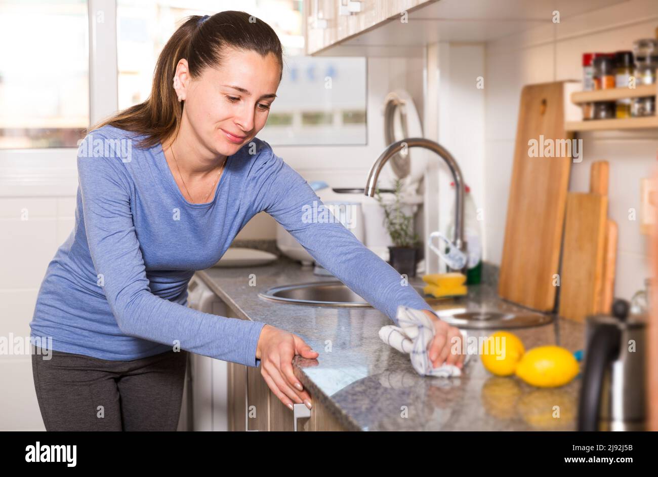 Woman cleaning kitchen with rag Stock Photo - Alamy