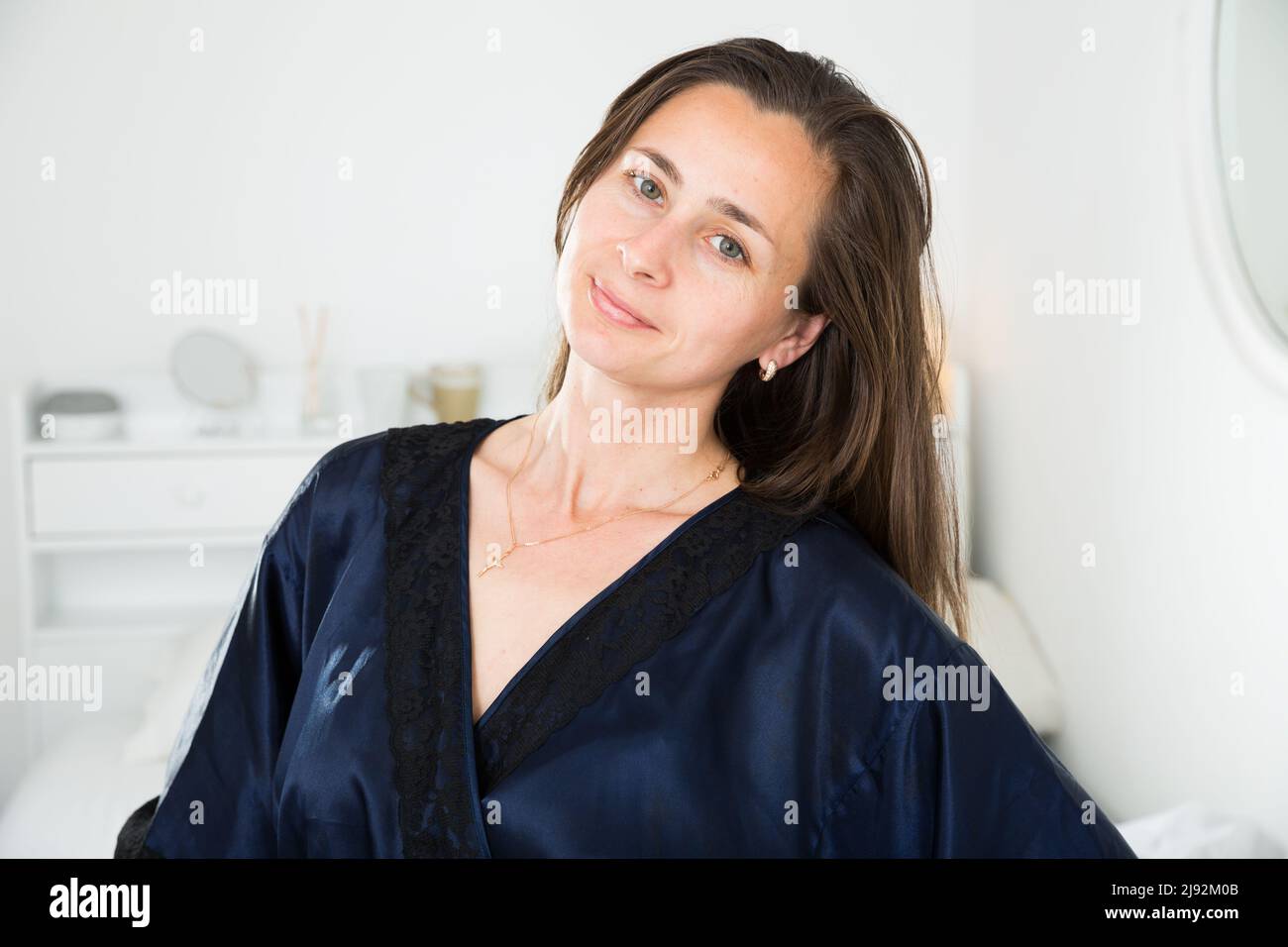 Cute woman in a blue silk robe in bedroom Stock Photo - Alamy