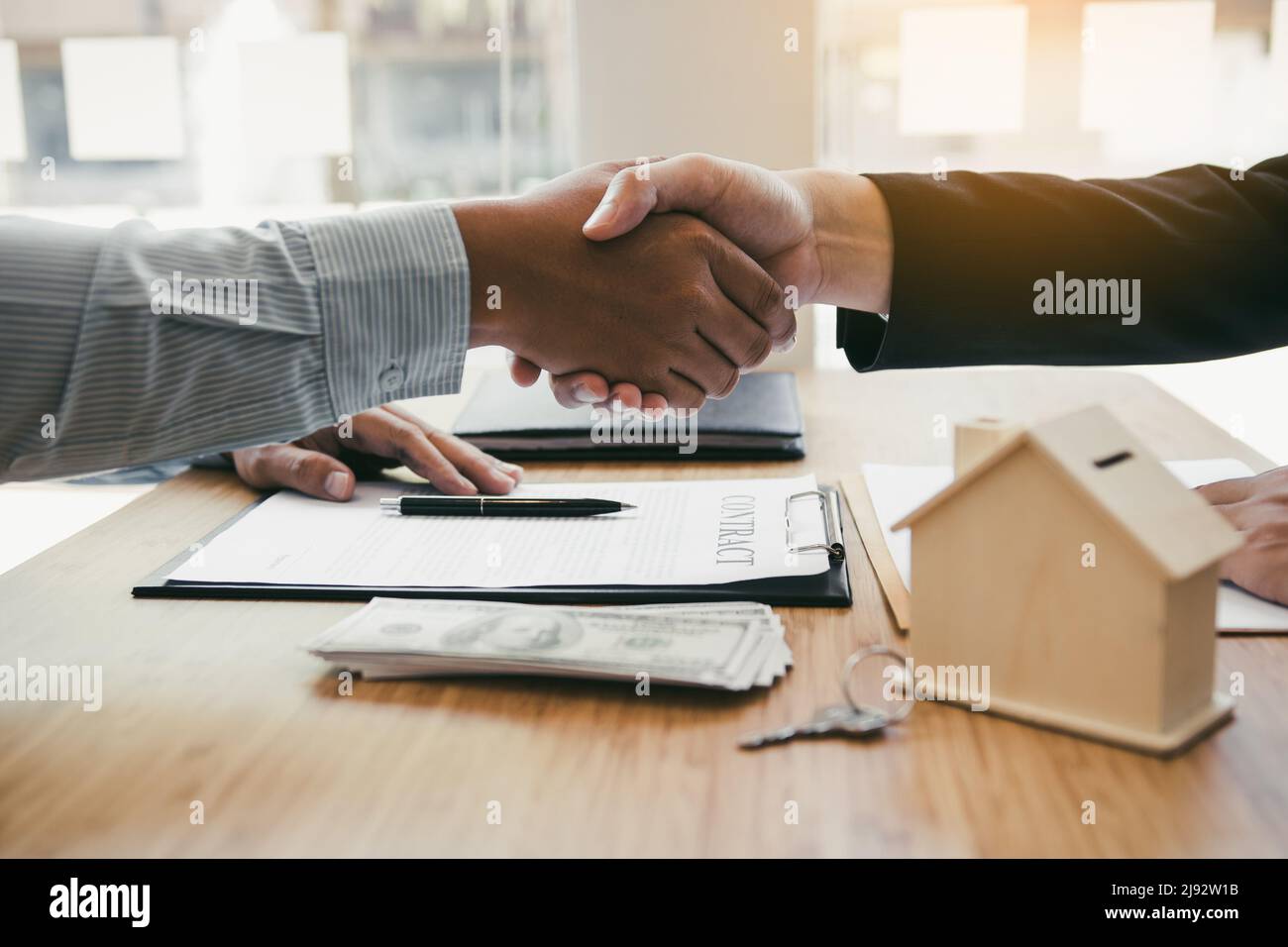 Home sales agents and buyers work on signing new homes and shaking ...