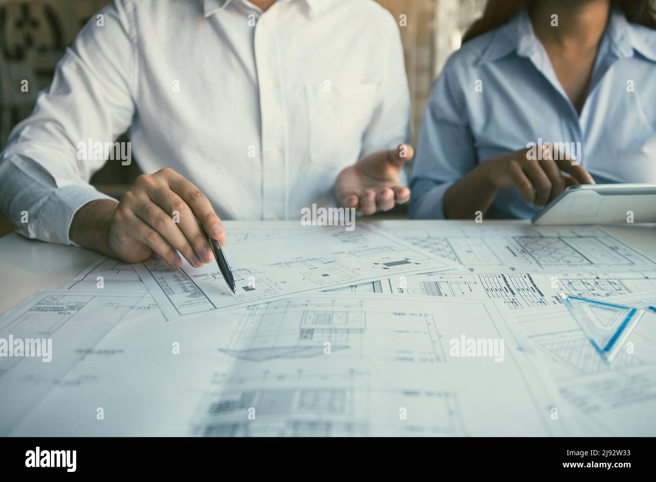 Engineering man showing blueprint detail for people buying house Stock ...