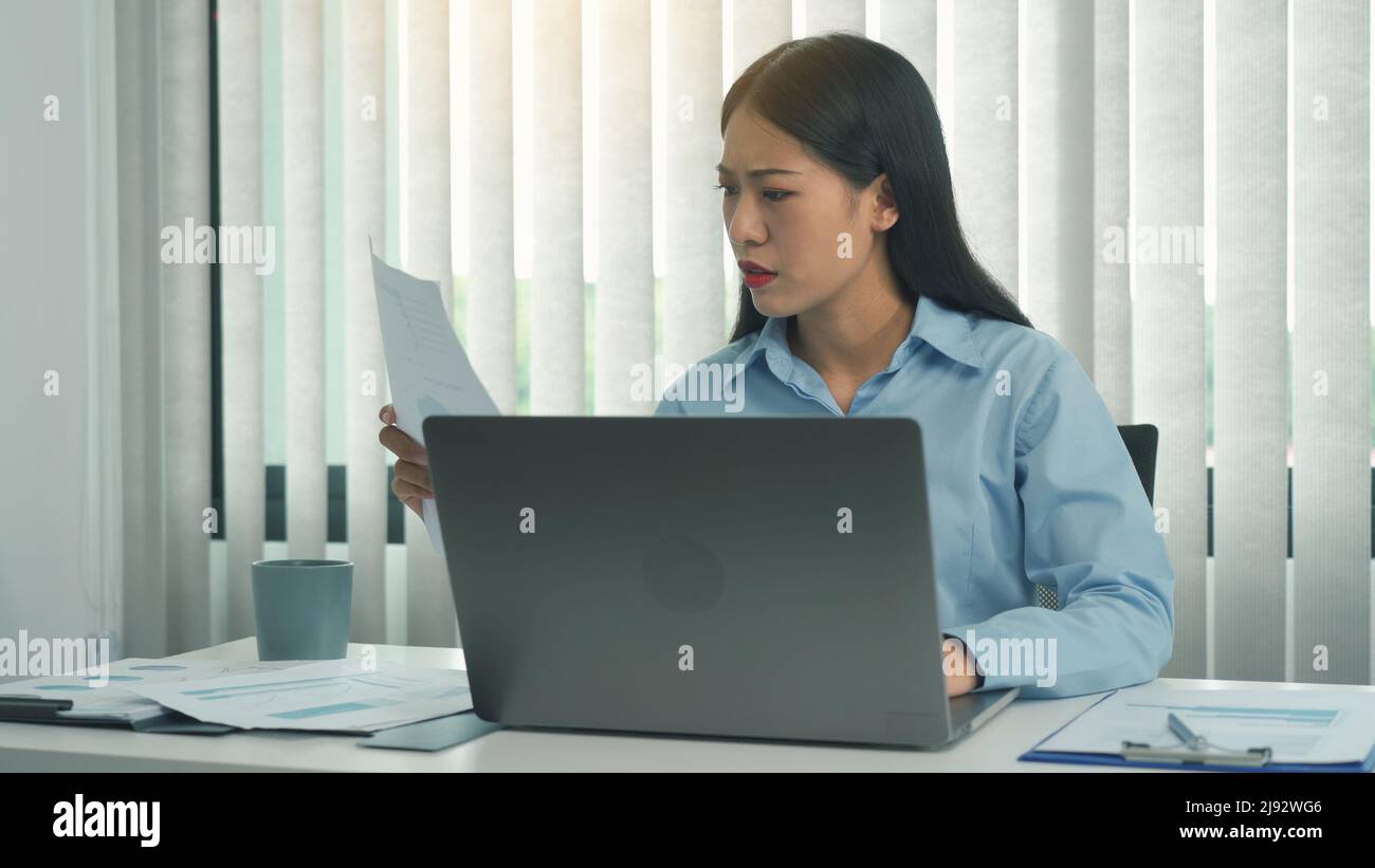 Young asian women are frustrated about the documents while using the ...
