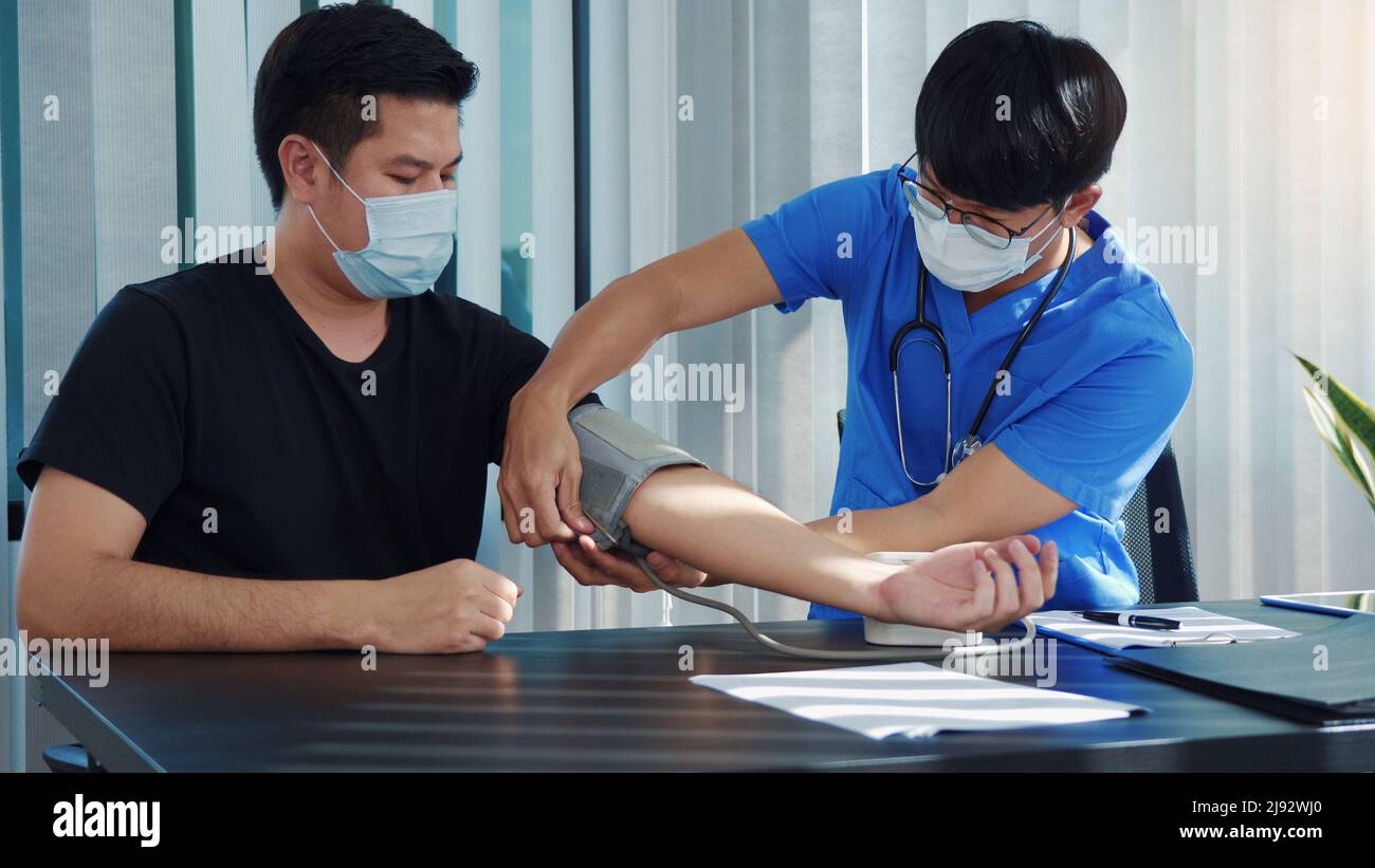 Asian doctor is measuring the patient's pressure during the annual ...
